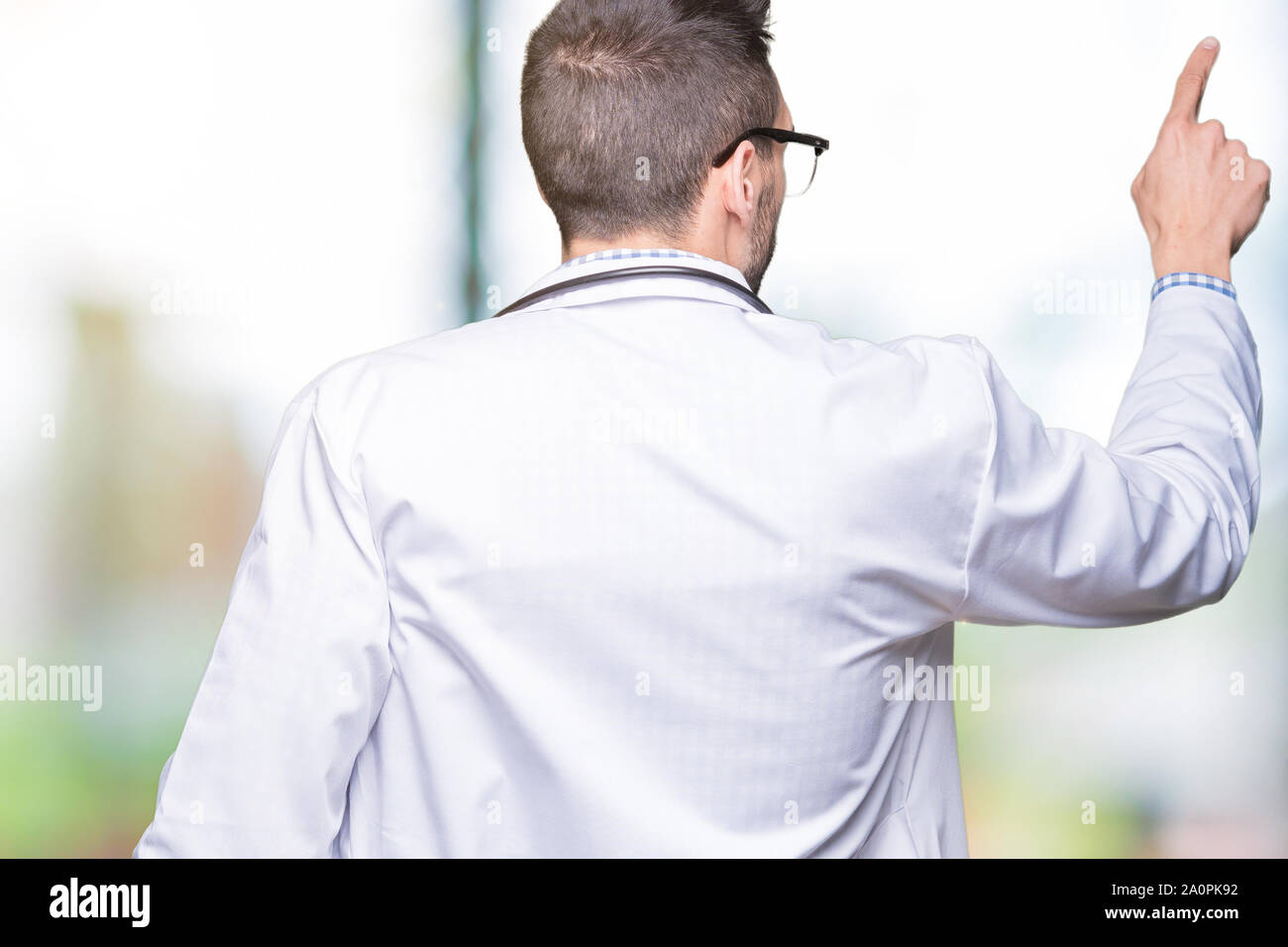 Handsome young doctor man over isolated background Posing backwards ...