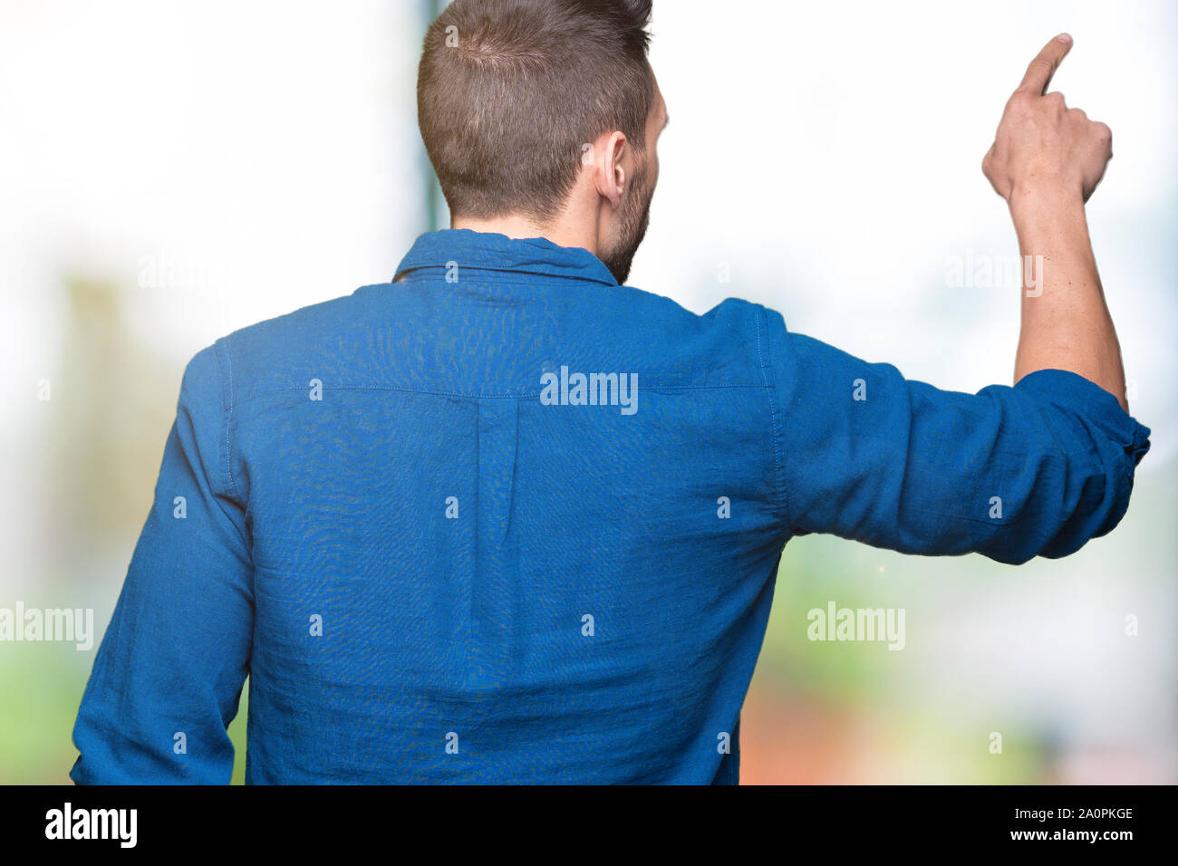 Young handsome man over isolated background Posing backwards pointing ...