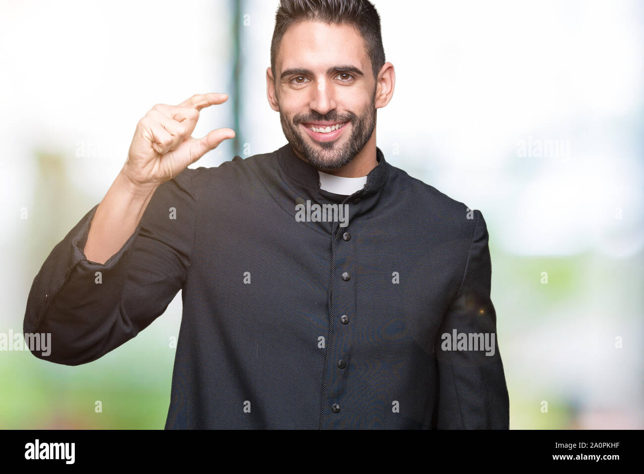 Young Christian priest over isolated background smiling and confident ...