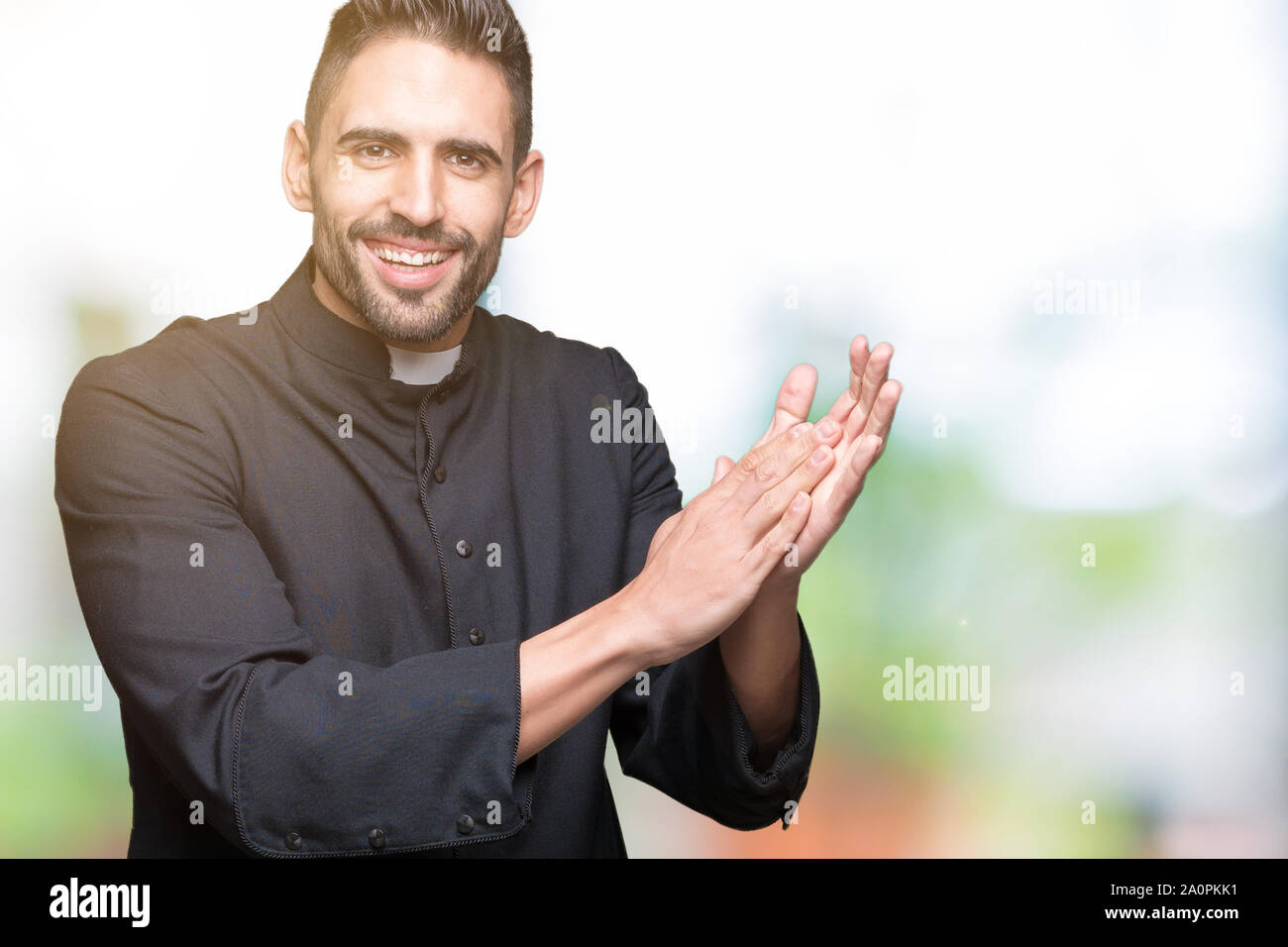 Young Christian priest over isolated background Clapping and applauding ...