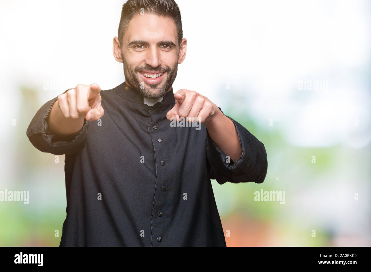 Young Christian priest over isolated background Pointing to you and the ...