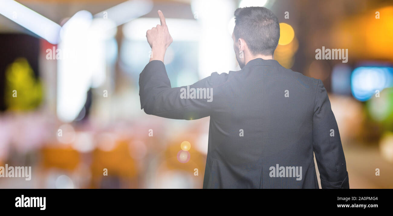 Young Christian priest over isolated background Posing backwards ...