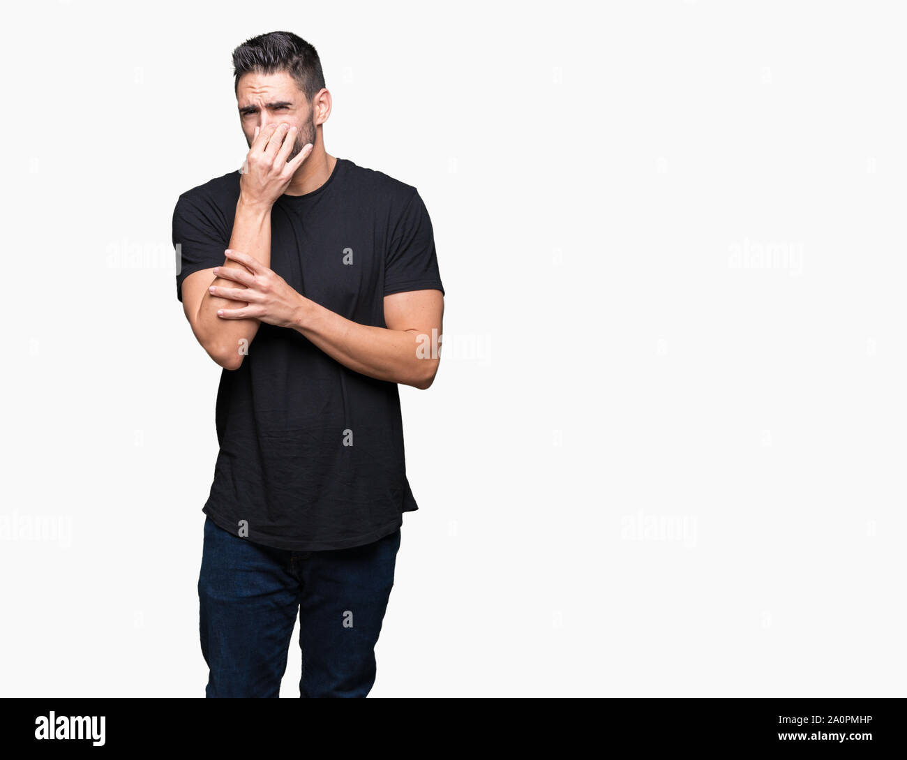 Young handsome man over isolated background smelling something stinky ...