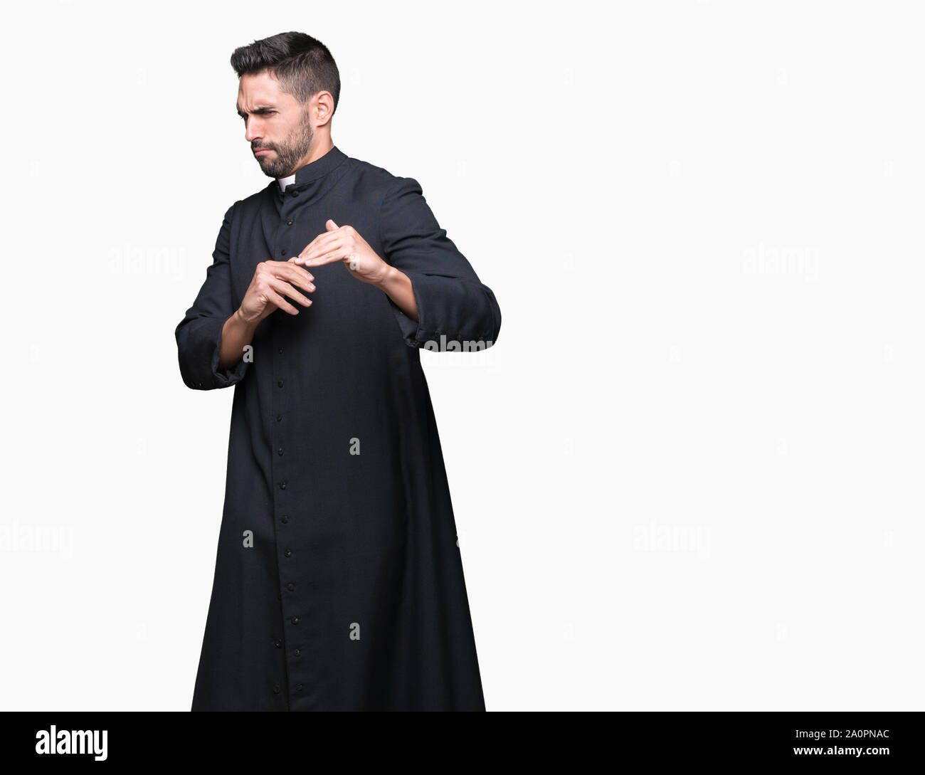 Young Christian priest over isolated background disgusted expression ...