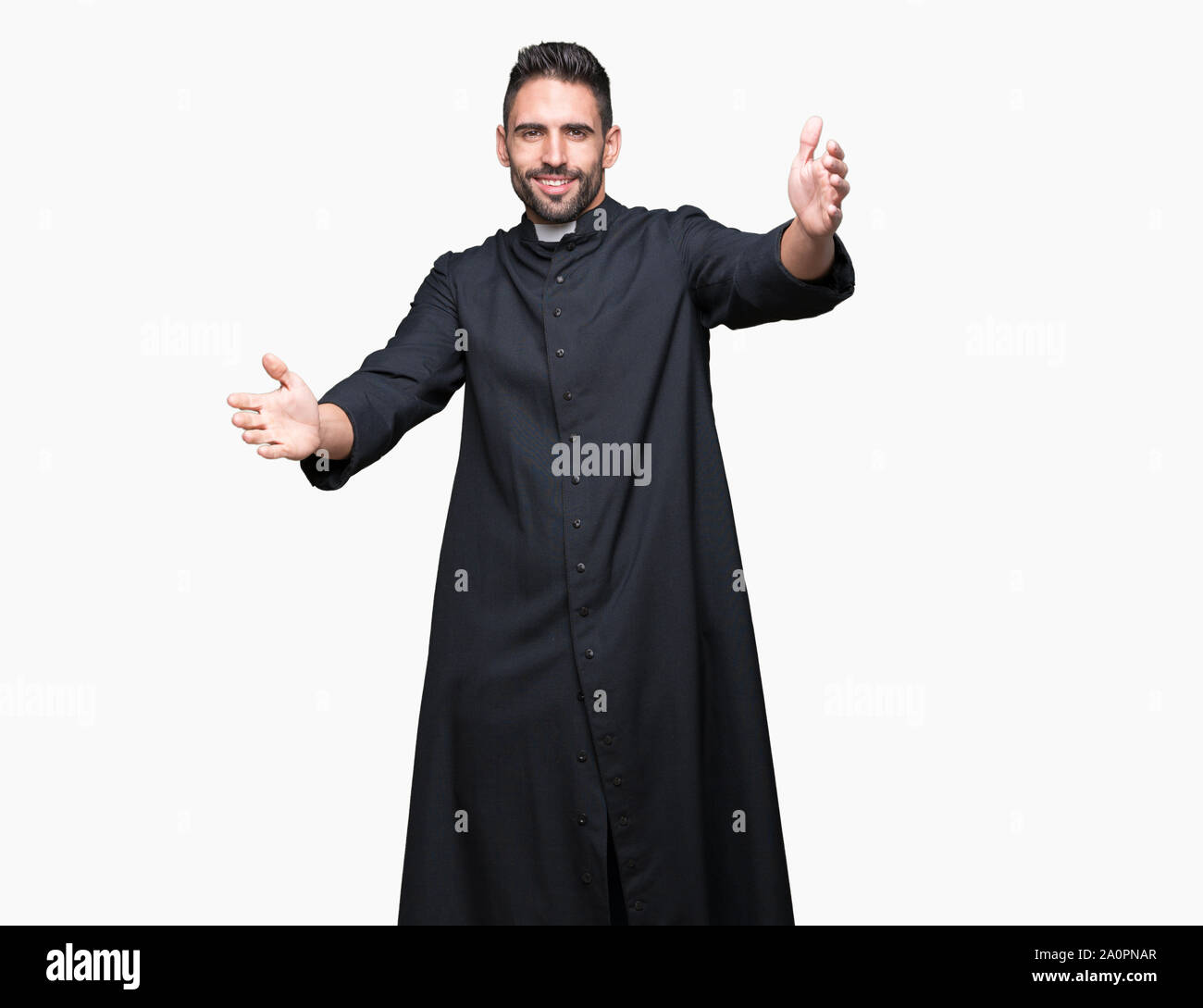 Young Christian priest over isolated background looking at the camera ...