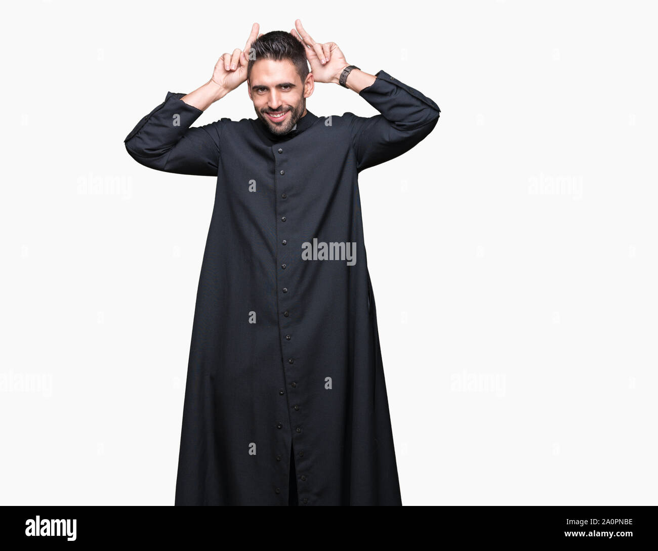 Young Christian priest over isolated background Posing funny and crazy ...
