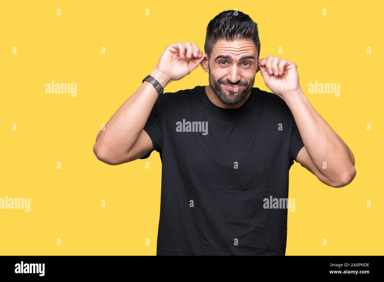 Young handsome man over isolated background Smiling pulling ears with ...