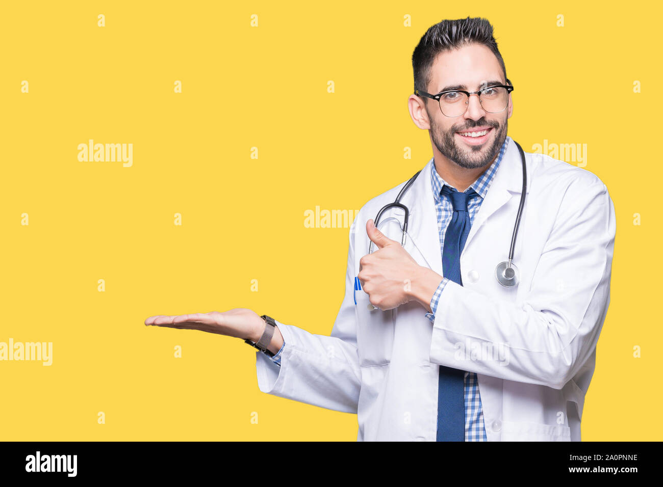Handsome young doctor man over isolated background Showing palm hand ...
