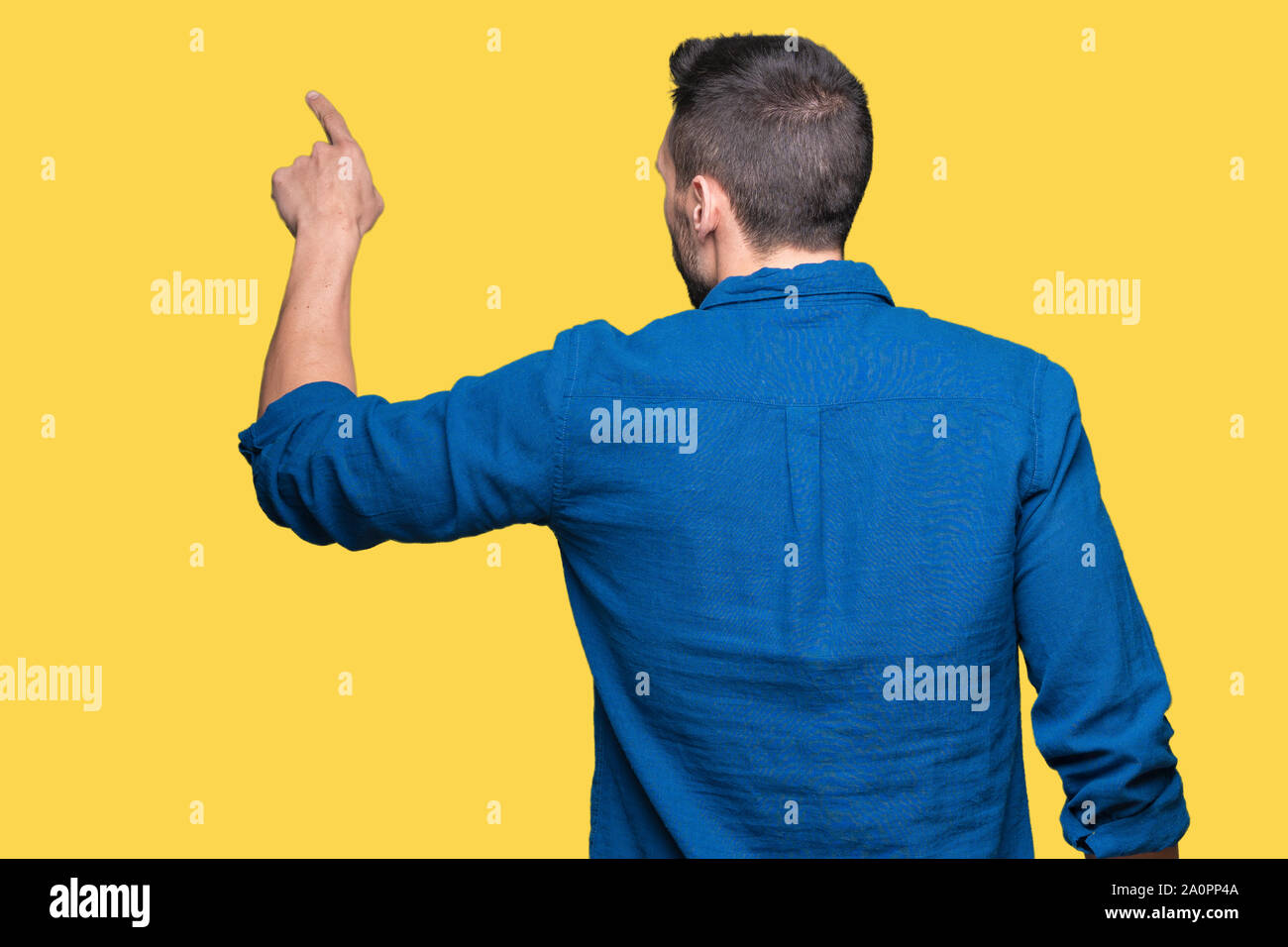 Young handsome man over isolated background Posing backwards pointing ...