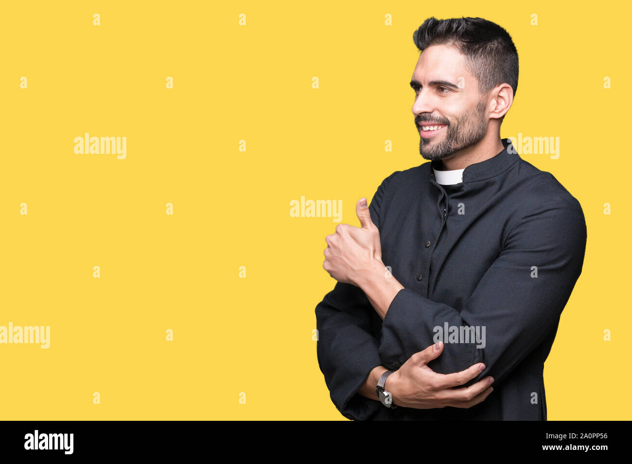 Young Christian priest over isolated background Looking proud, smiling ...