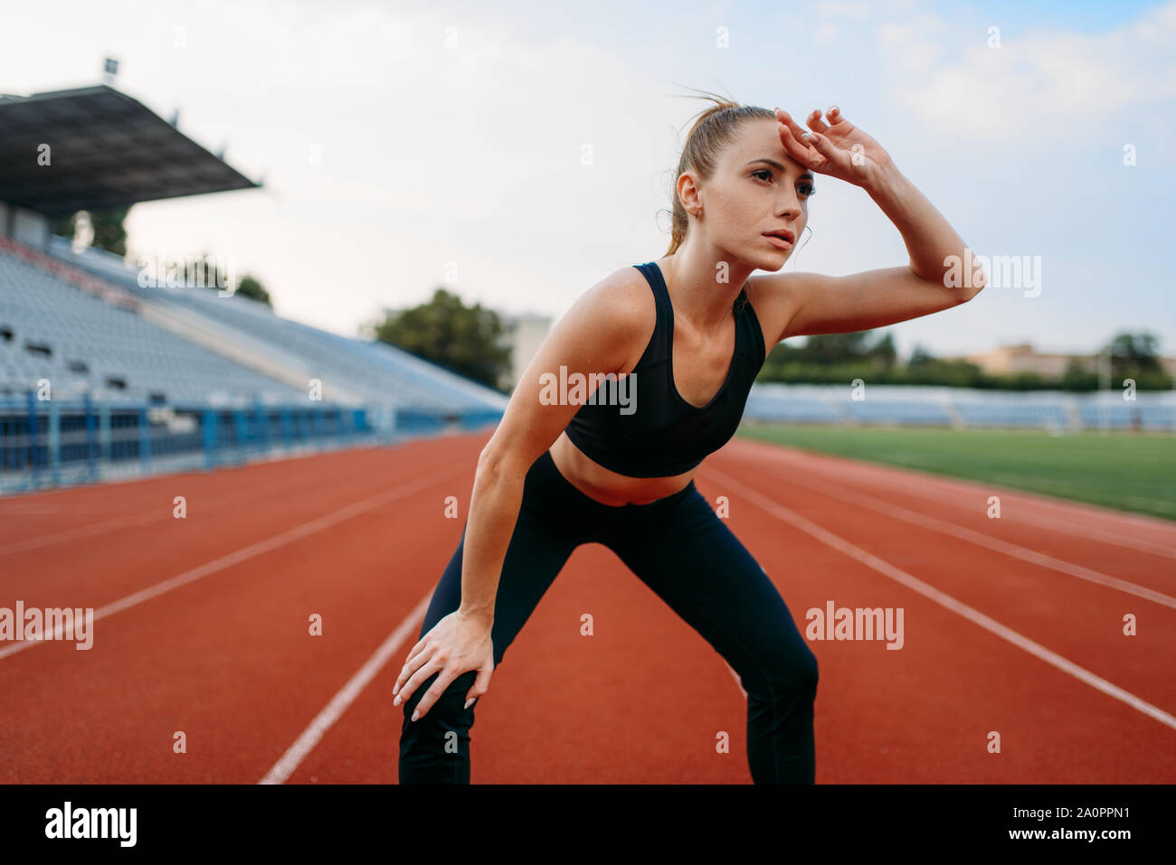 Tired female jogger, training on stadium Stock Photo - Alamy