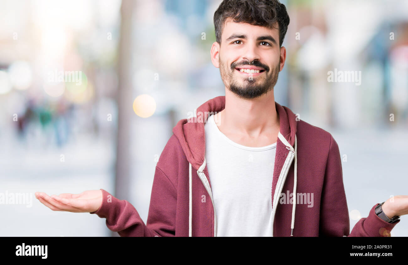 Young handsome man over isolated background Smiling showing both hands ...
