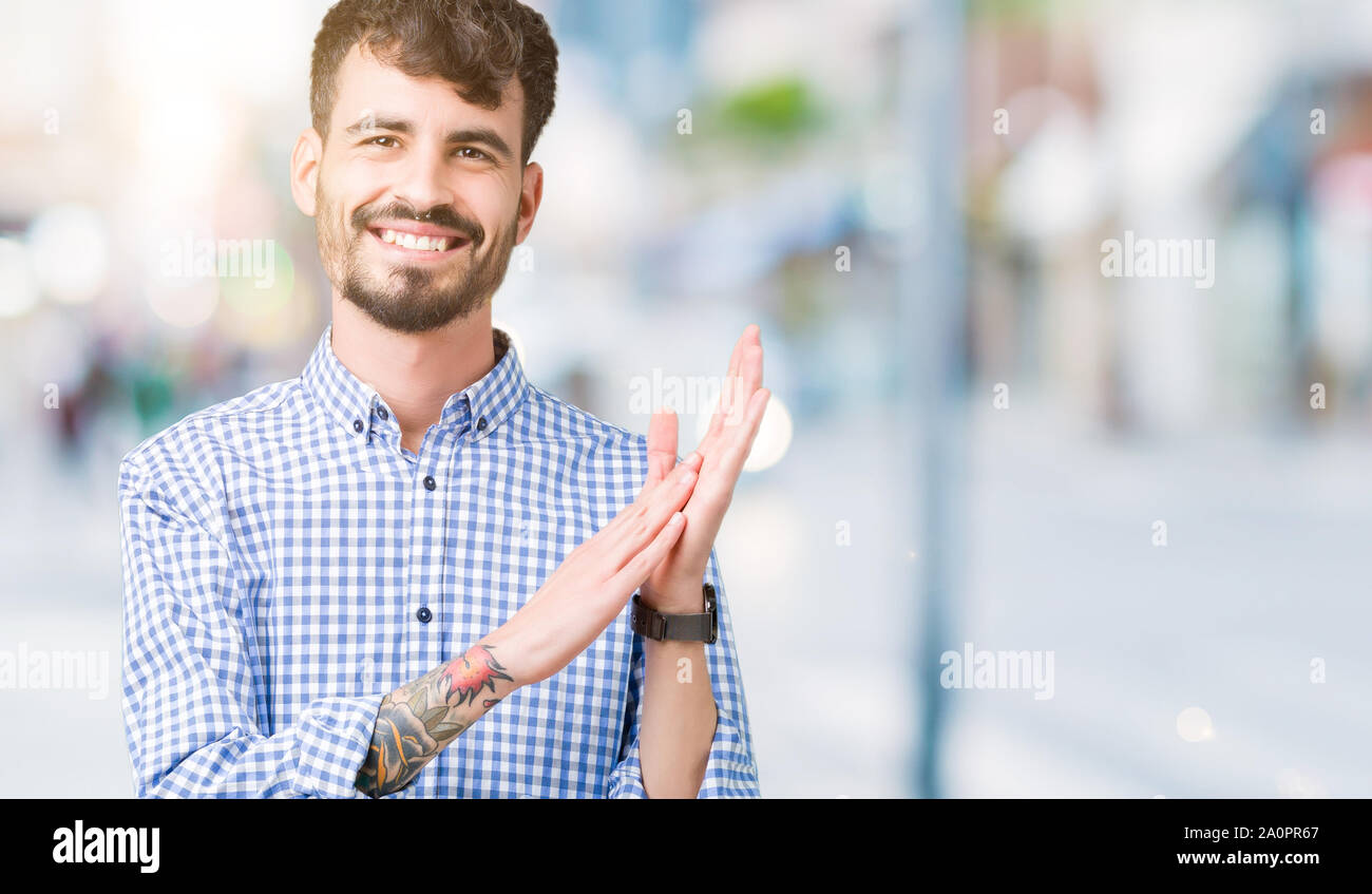 Young handsome business man over isolated background Clapping and ...