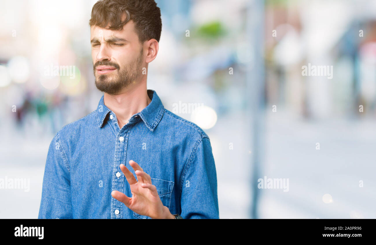 Young handsome man over isolated background disgusted expression ...