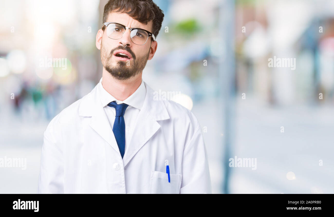 Young professional scientist man wearing white coat over isolated ...