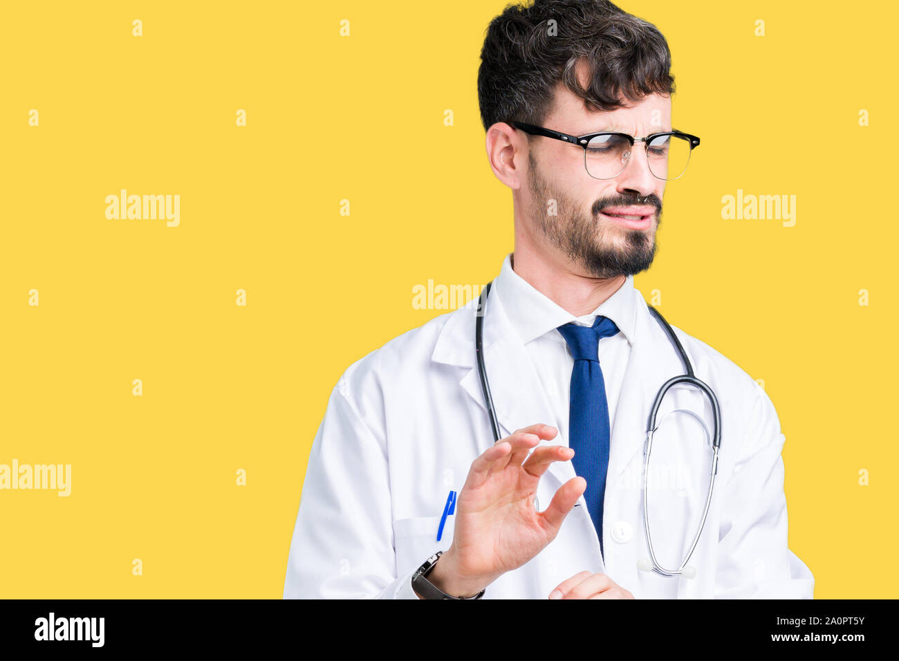 Young doctor man wearing hospital coat over isolated background ...
