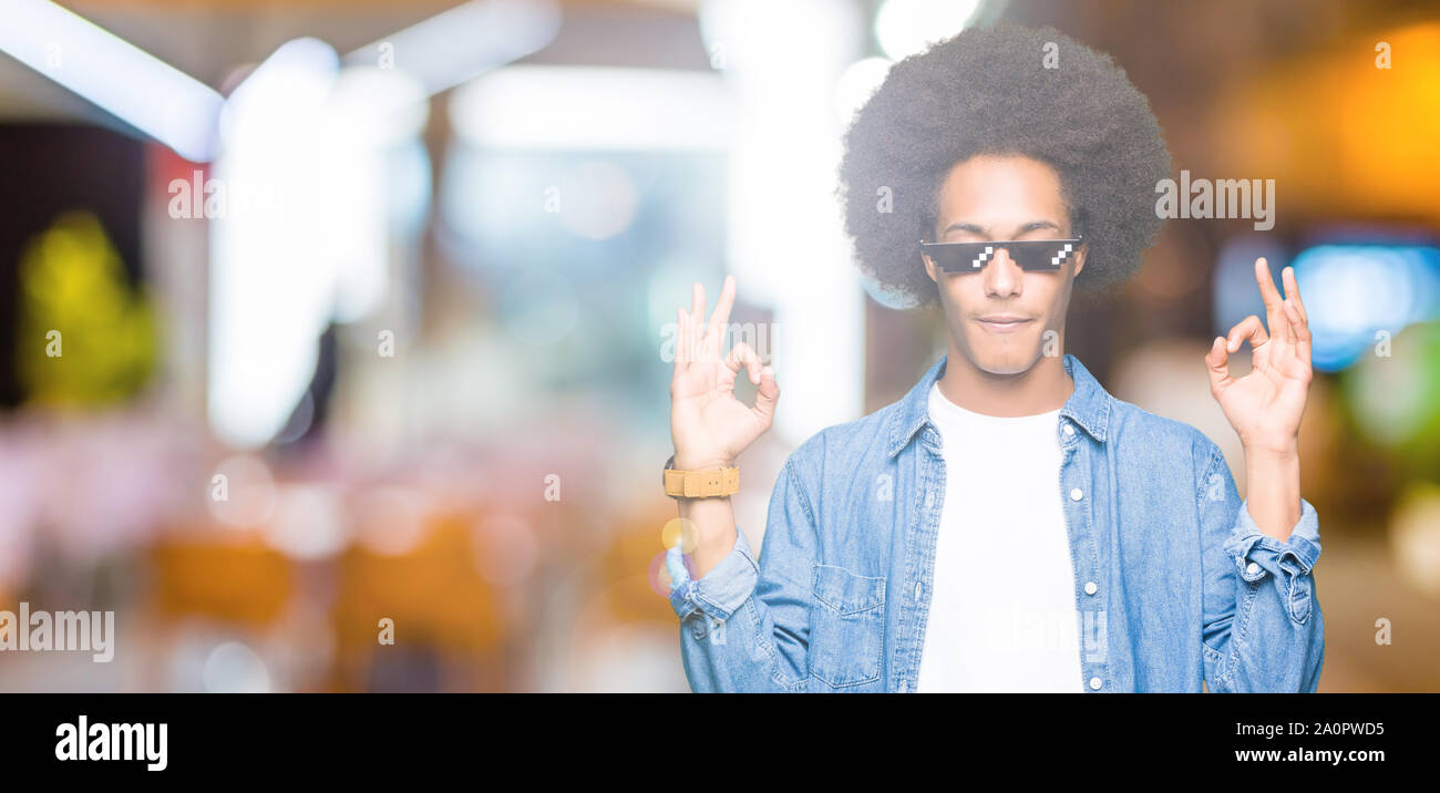 Young african american man with afro hair wearing thug life glasses ...