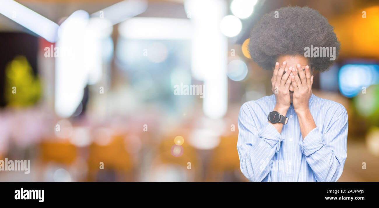 Young african american man with afro hair with sad expression covering ...