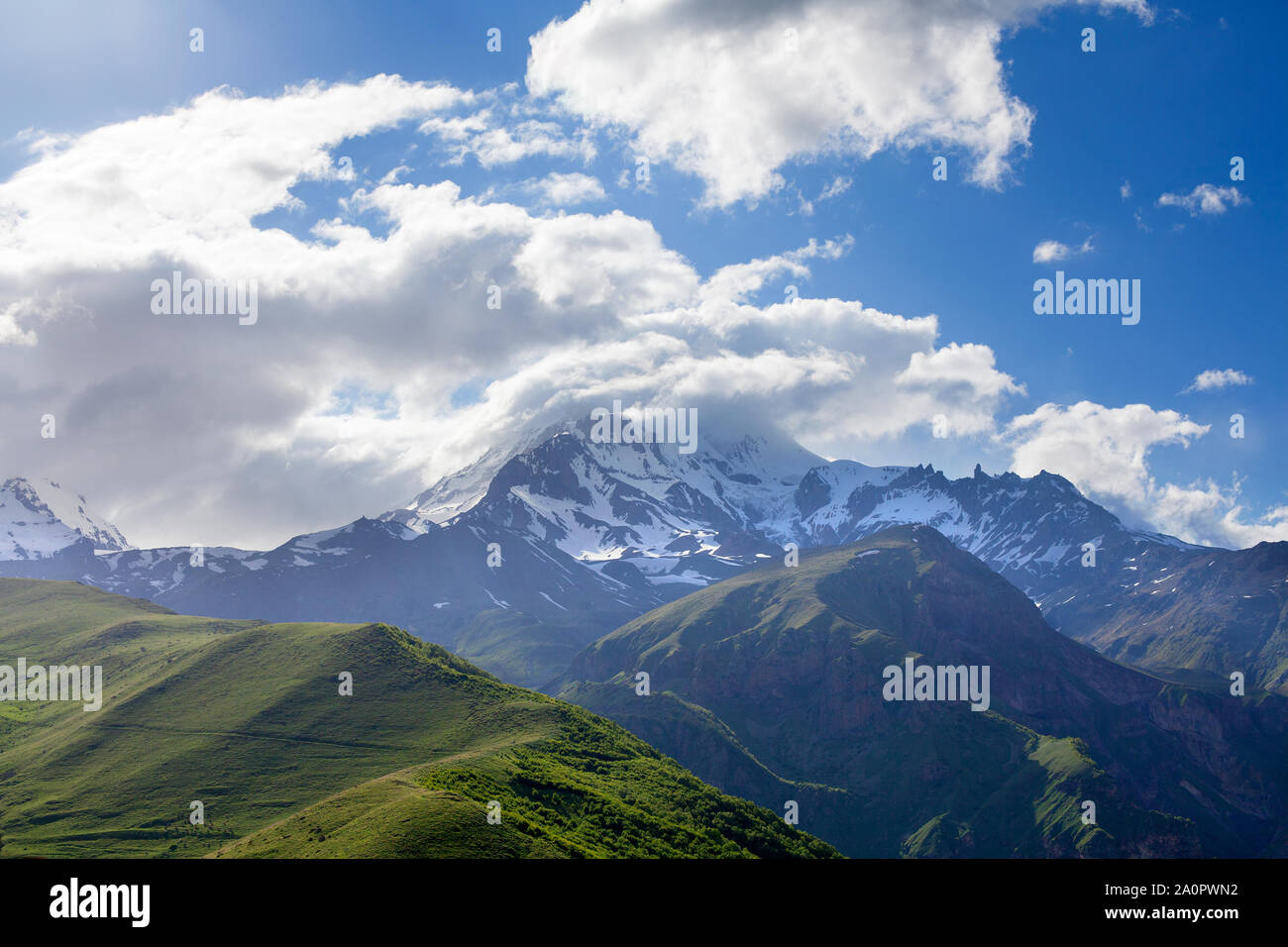 Panorama landscape mountain peaks in snow and green hills, deep blue ...