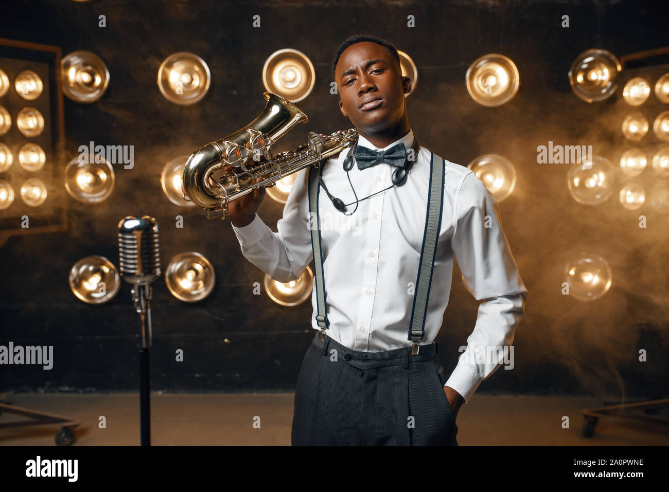 Black jazz performer poses with saxophone on stage Stock Photo - Alamy