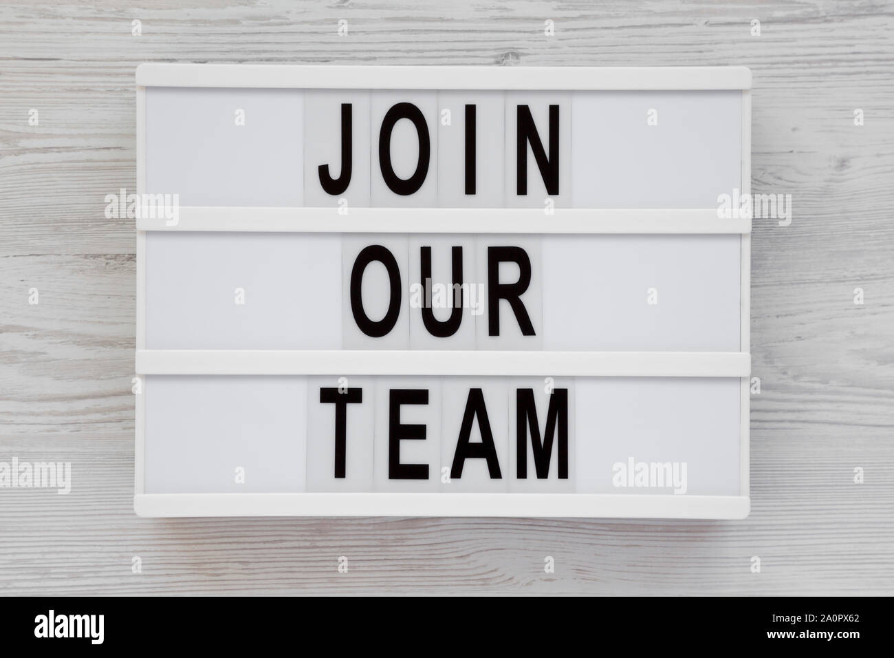 Top view, 'Join our team' words on a modern board on a white wooden ...