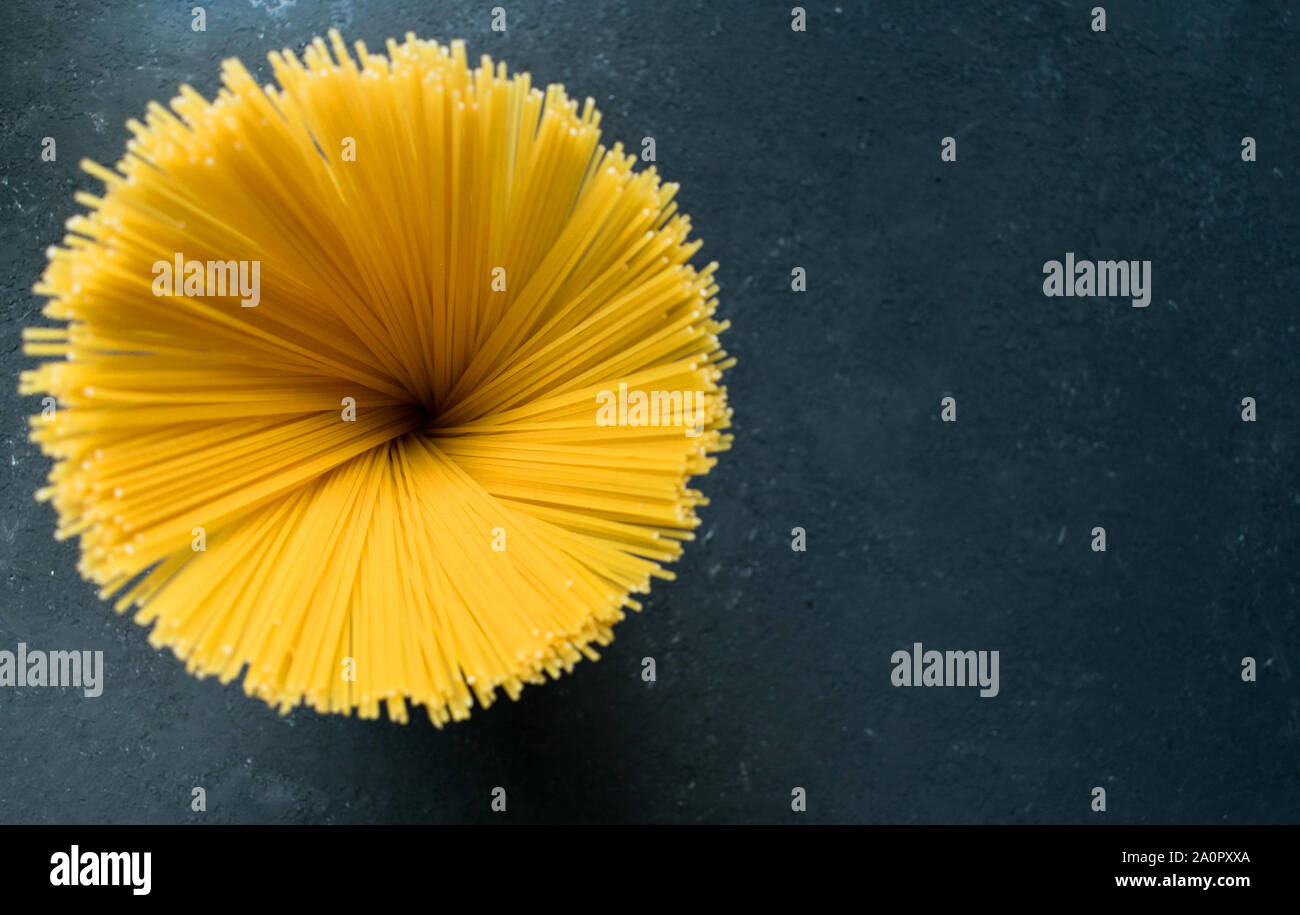 Yellow long spaghetti on a black background. Yellow Italian pasta. Raw ...