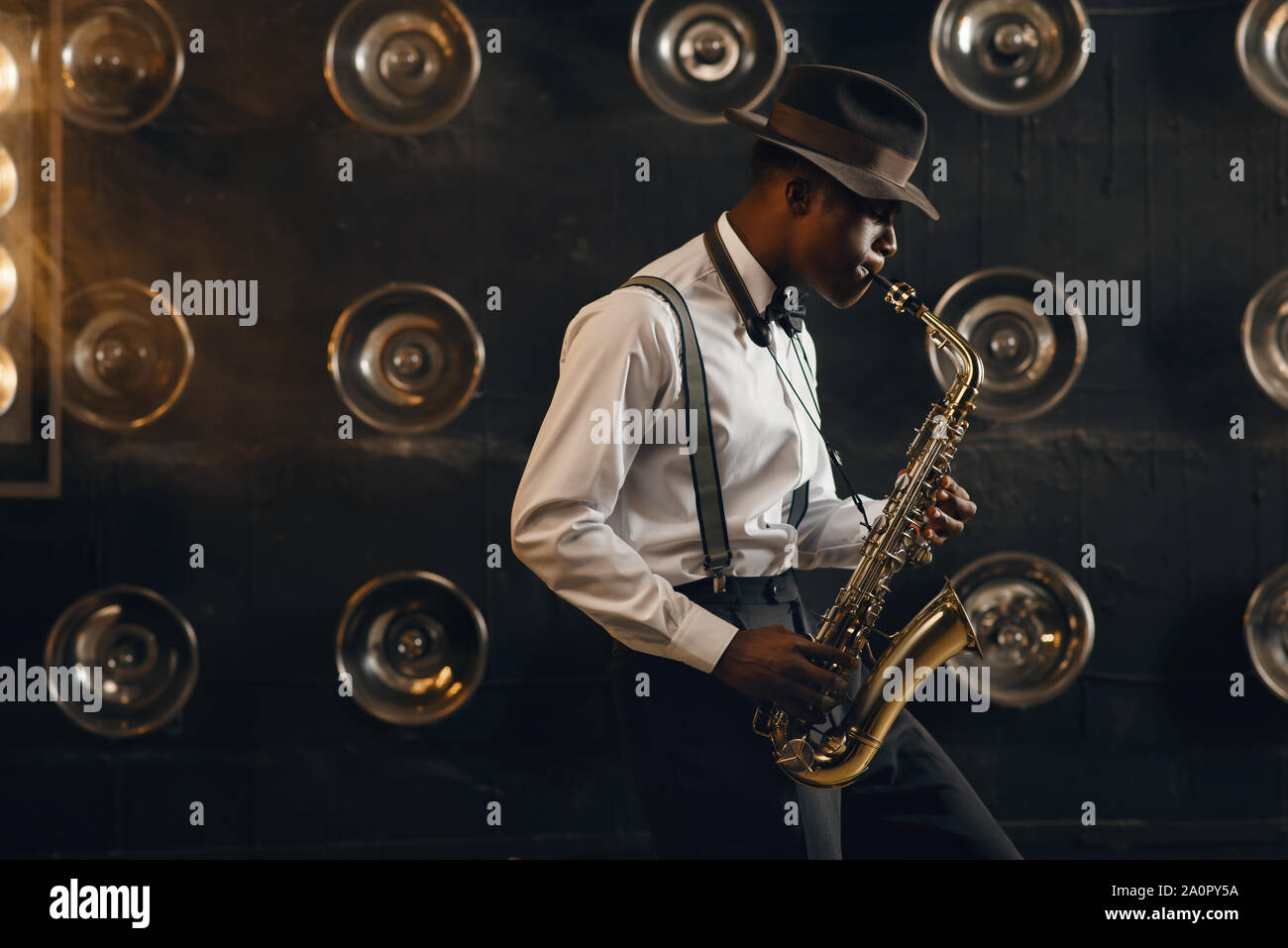 Black jazzman in hat plays the saxophone on stage Stock Photo - Alamy