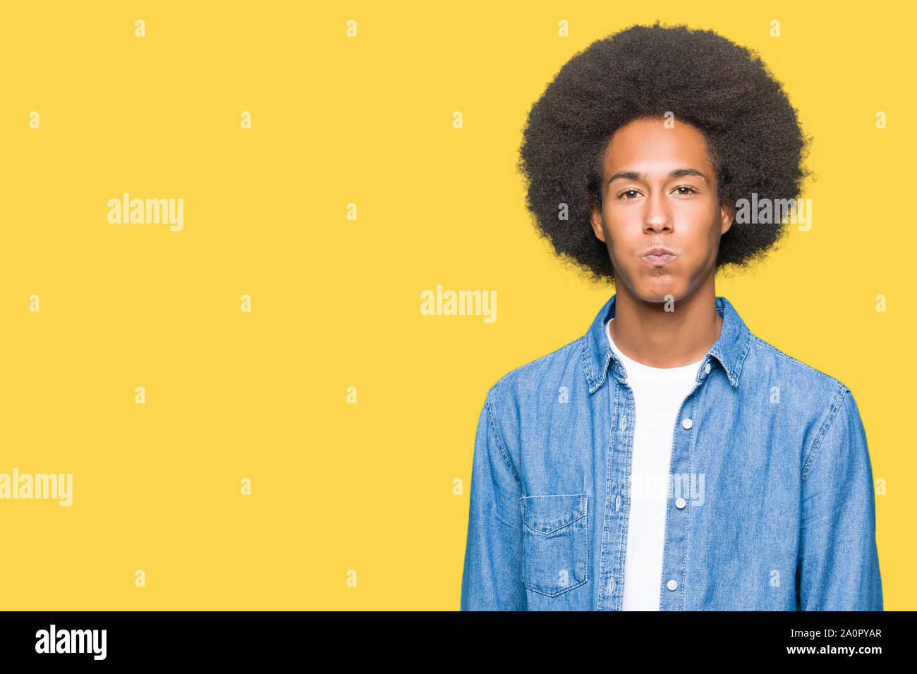 Young african american man with afro hair puffing cheeks with funny ...