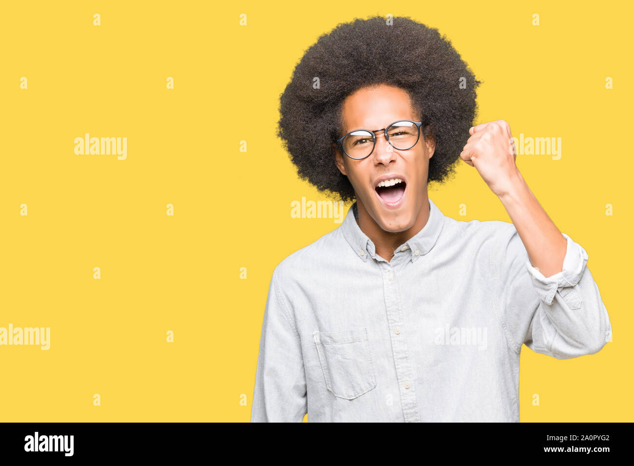 Young african american man with afro hair wearing glasses angry and mad ...