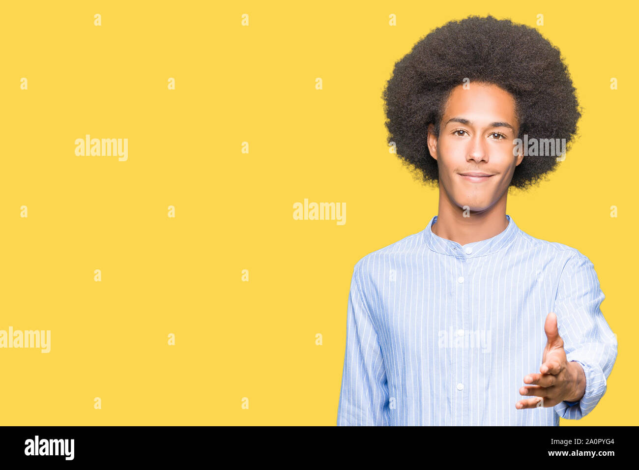 Young african american man with afro hair smiling friendly offering ...