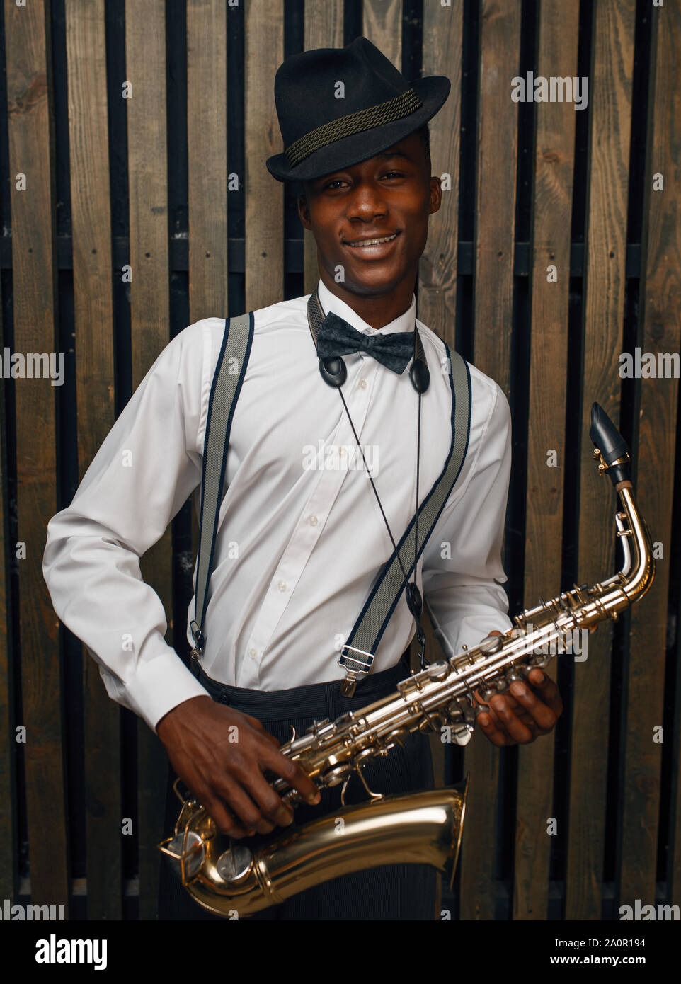 Black smiling jazz musician poses with saxophone Stock Photo - Alamy