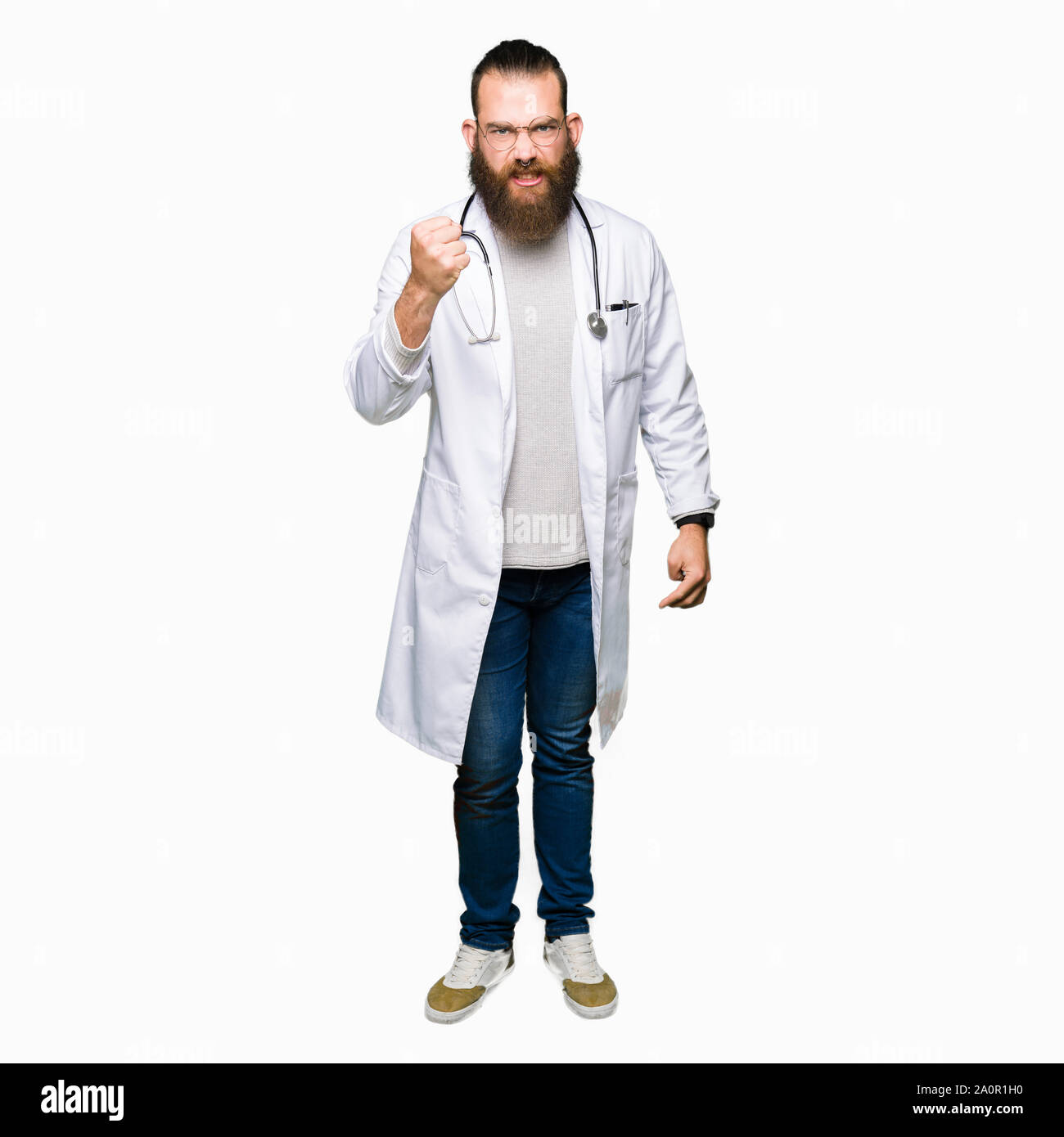 Young blond doctor man with beard wearing medical coat angry and mad ...