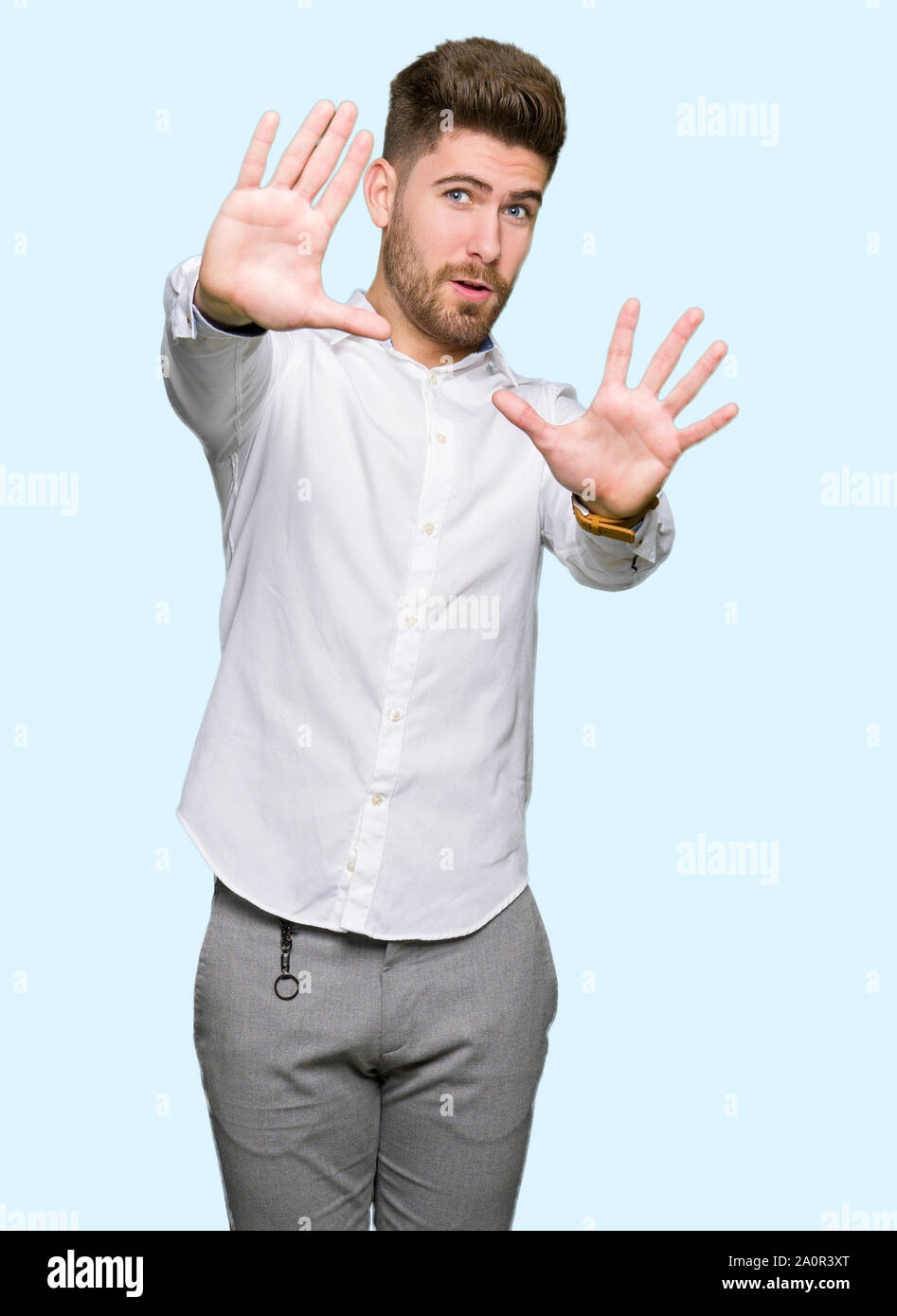 Young handsome business man afraid and terrified with fear expression ...