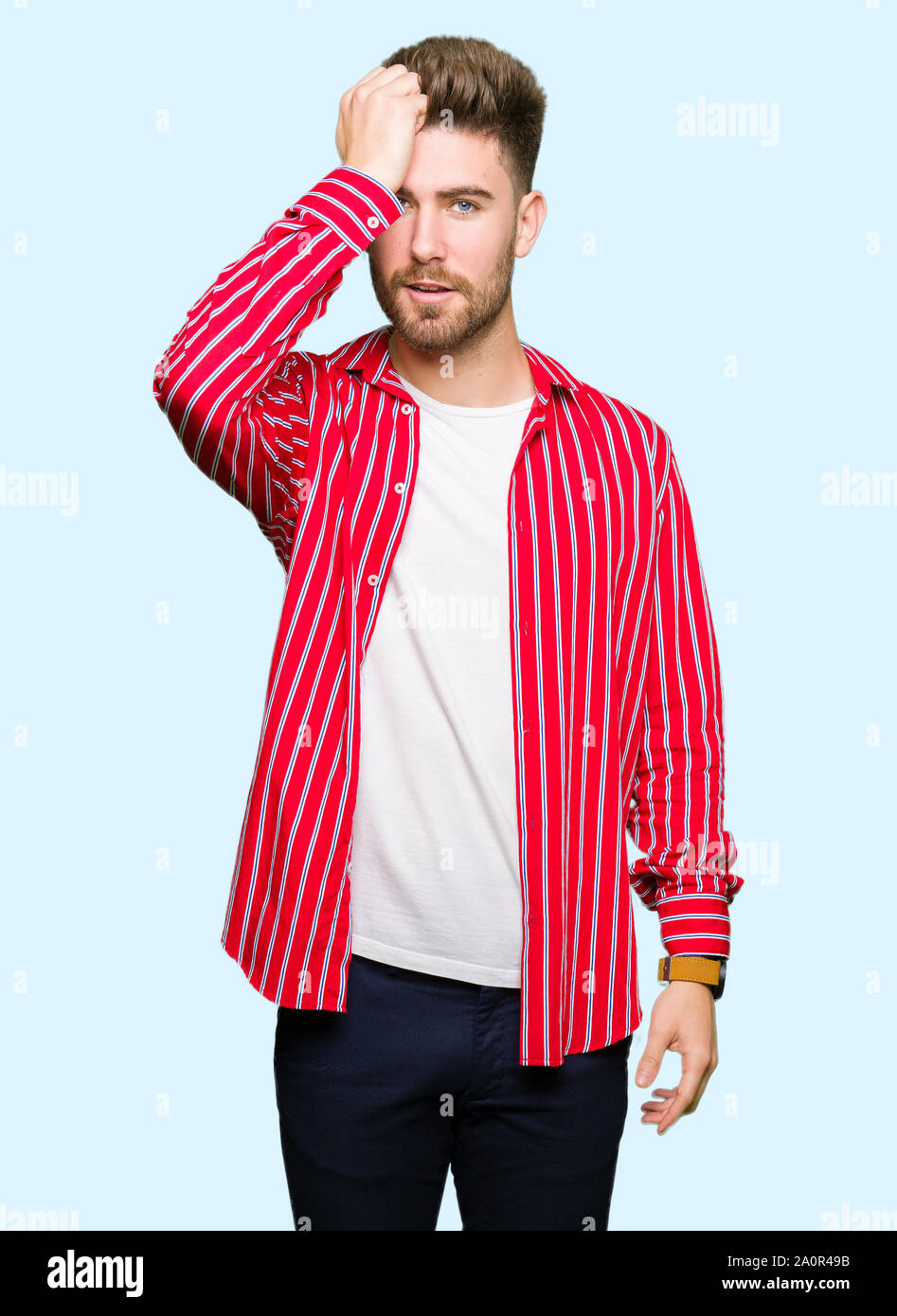 Young handsome man wearing red shirt surprised with hand on head for ...