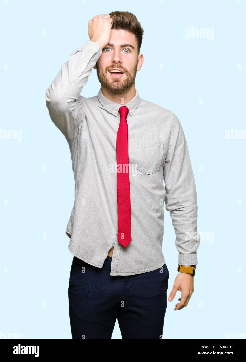 Young handsome business man surprised with hand on head for mistake ...