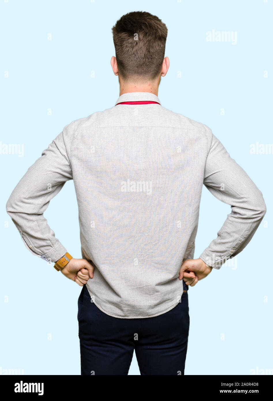 Young handsome business man standing backwards looking away with arms ...