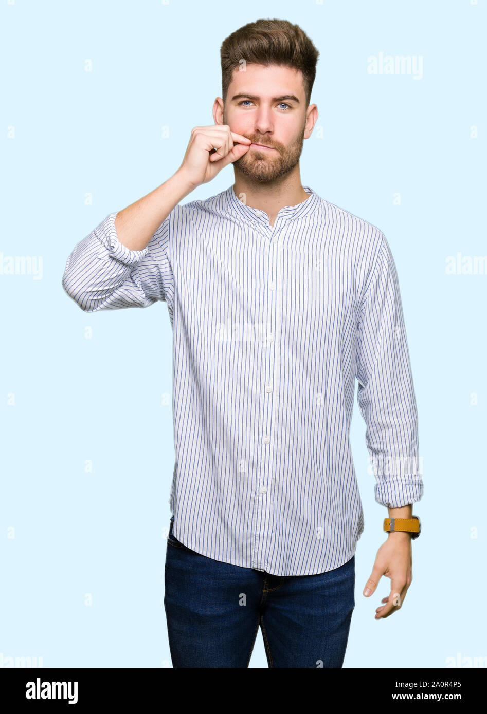 Young handsome man mouth and lips shut as zip with fingers. Secret and ...