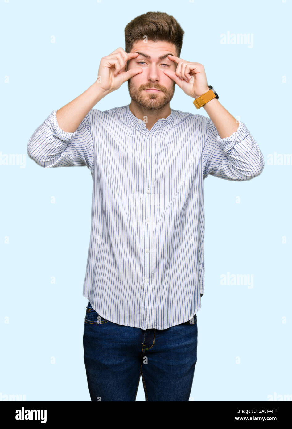 Young handsome man Trying to open eyes with fingers, sleepy and tired ...