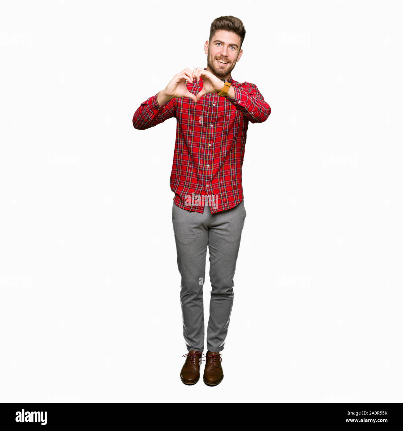 Young handsome man smiling in love showing heart symbol and shape with ...