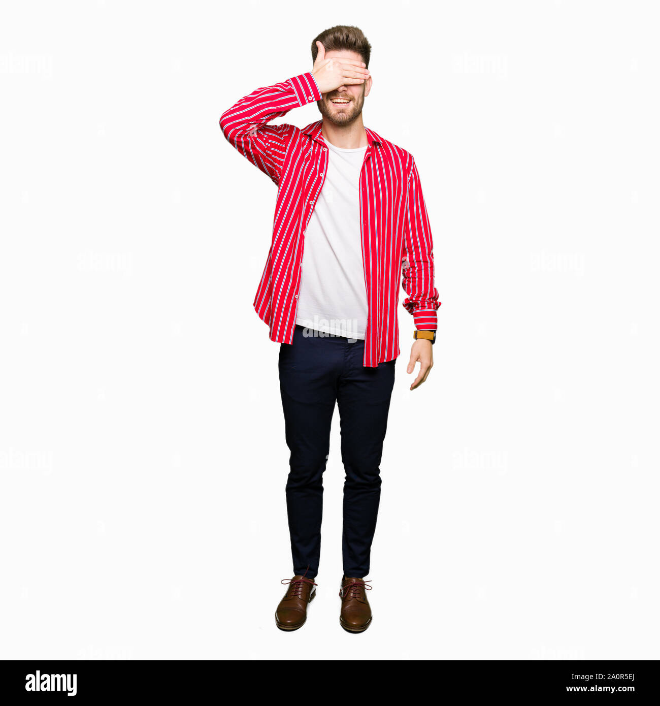 Young handsome man wearing red shirt smiling and laughing with hand on ...
