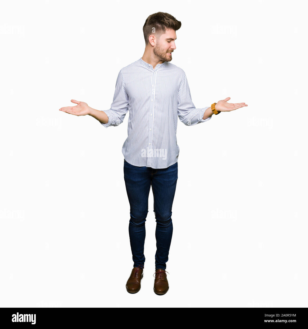 Young handsome man Smiling showing both hands open palms, presenting ...