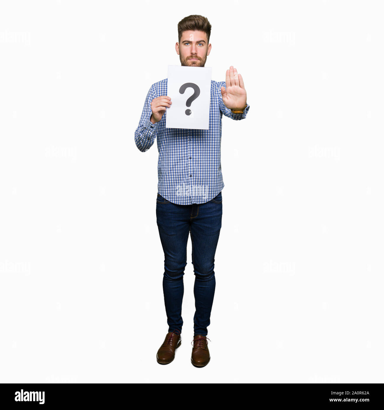 Young handsome man holding paper with question mark with open hand ...