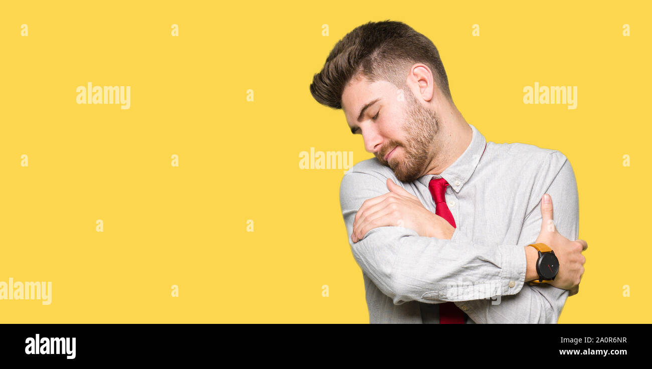 Young handsome business man Hugging oneself happy and positive, smiling ...