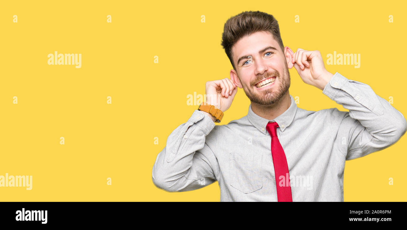 Young handsome business man Smiling pulling ears with fingers, funny ...