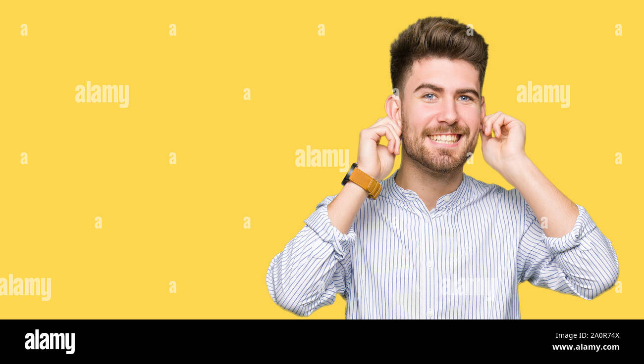 Young handsome man Smiling pulling ears with fingers, funny gesture ...