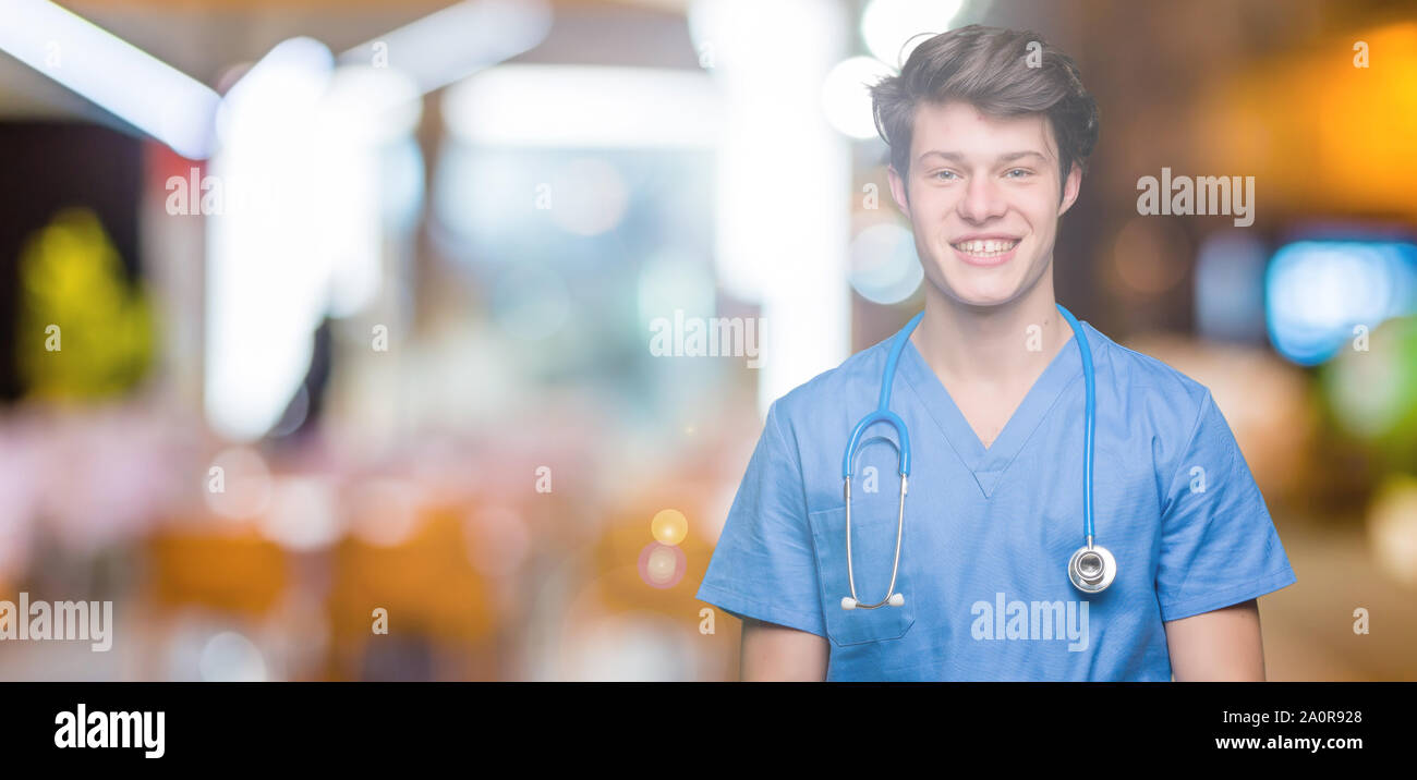 Young doctor wearing medical uniform over isolated background with a ...