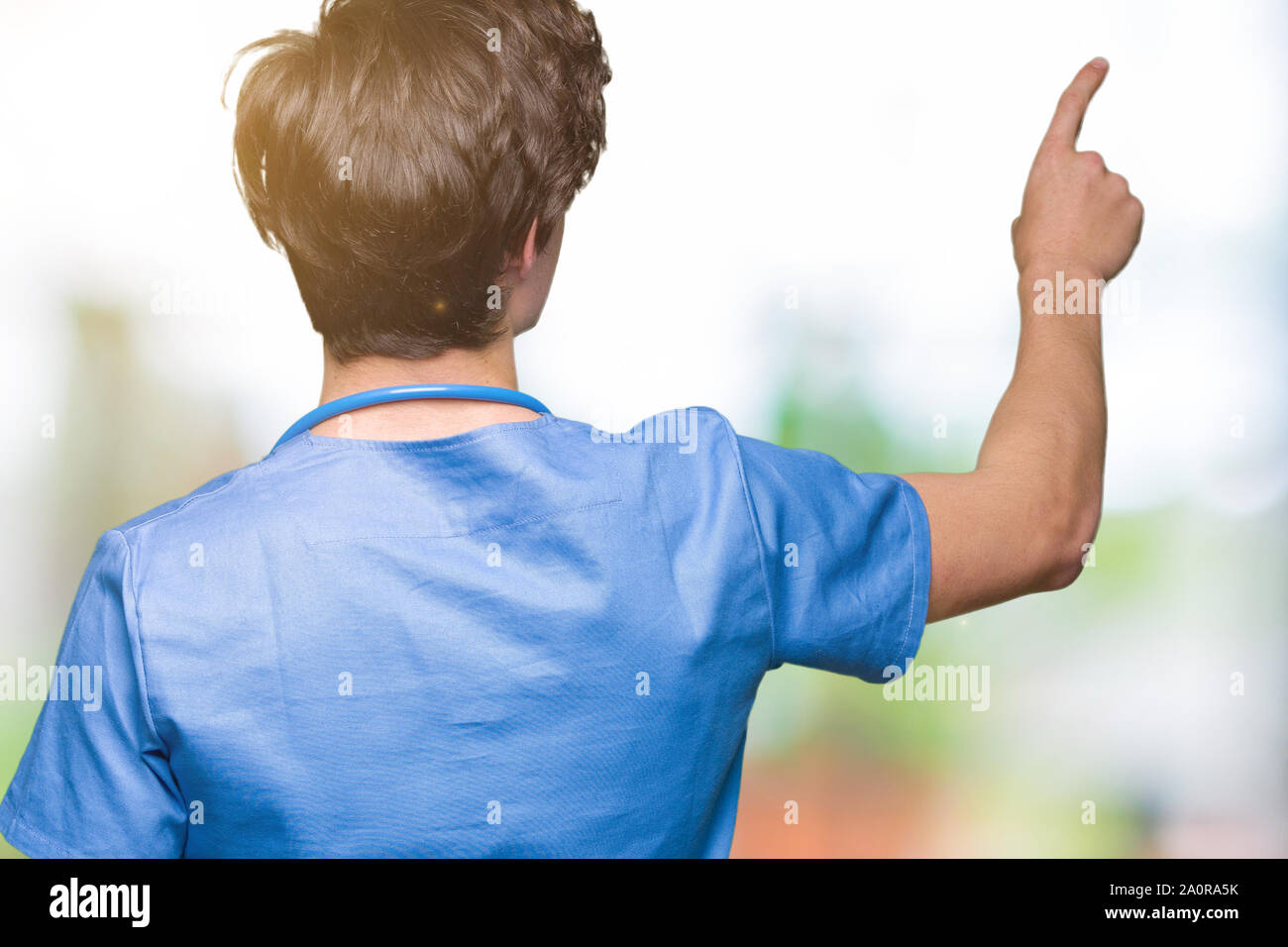 Young doctor wearing medical uniform over isolated background Posing ...