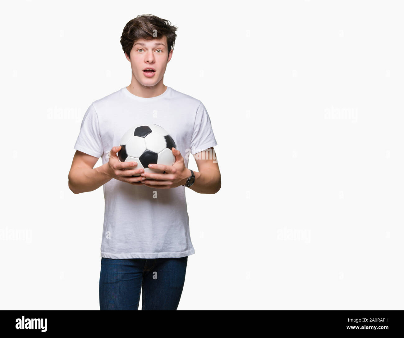 Young man holding soccer football ball over isolated background scared ...