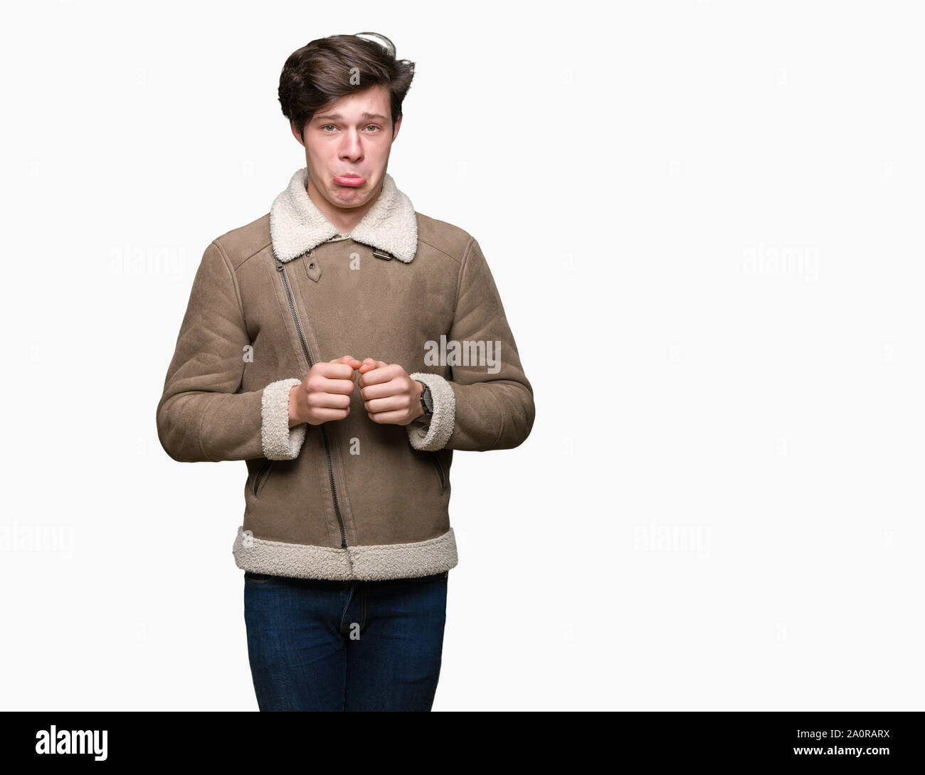 Young handsome man wearing winter coat over isolated background ...