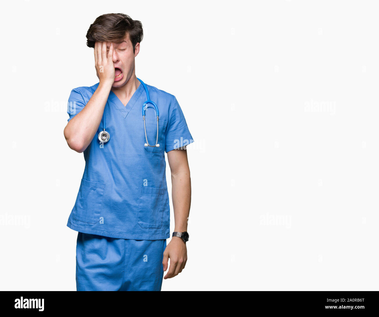 Young doctor wearing medical uniform over isolated background Yawning ...